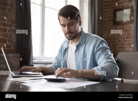Handsome Business Owner Man Calculating Project Expenses Using Laptop Stock Photo Alamy