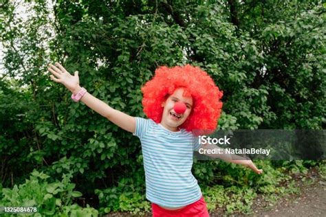 빨간 가발과 코를 입은 아이 광대가 야외에 서서 미소를 지었다 4월 1일 웃음의 날 생일 6 7 살에 대한 스톡 사진 및 기타 이미지 Istock