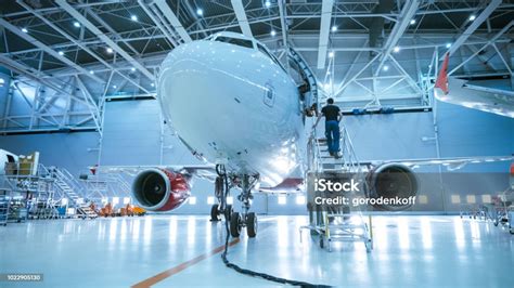 새로운 비행기 항공기 유지 보수 엔지니어 동안 항공기 정비 격납고에 서 브랜드 기술자 사다리를 통해 객실 내부 수리가 램프 항공