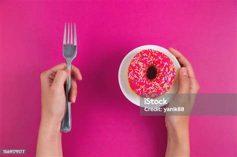 아침 식사 개념입니다 클로즈업 분홍색 배경에 포크와 도넛 모양의 쿠키가 있는 여성의 손 평면도 평평하게 누워 있다 사람들에 대한