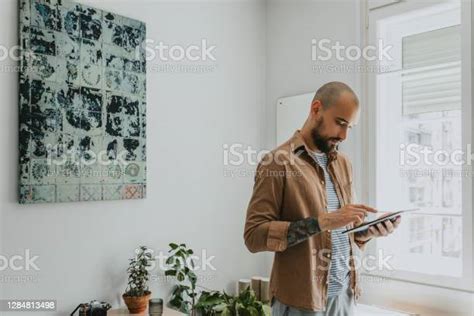 캐주얼 옷을 입은 젊은 남자 그의 거실에서 태블릿 Pc를 통해 그의 친구와 채팅 남자에 대한 스톡 사진 및 기타 이미지 남자 태블릿 가정 생활 Istock