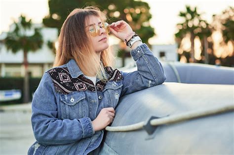 골드 백라이트 선글라스를 입은 아름다운 소녀 항구의 요트 배경에서 여름 일몰에 긴 금발 머리를 가진 데님 재킷 긴에 대한 스톡 사진 및 기타 이미지 Istock