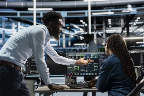 System Administrators To The Rescue Two It Technicians Using A Computer While Working In A Data