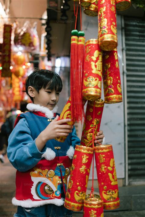 빨간색과 금색의 기둥 옆에 서 있는 어린 소년 사진 Unsplash의 음력 설날 이미지