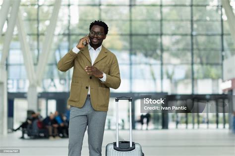 기내 반입 수하물을 가지고 공항에서 전화 통화하는 사업가 25 29세에 대한 스톡 사진 및 기타 이미지 25 29세 가벼운 여행 공항 Istock
