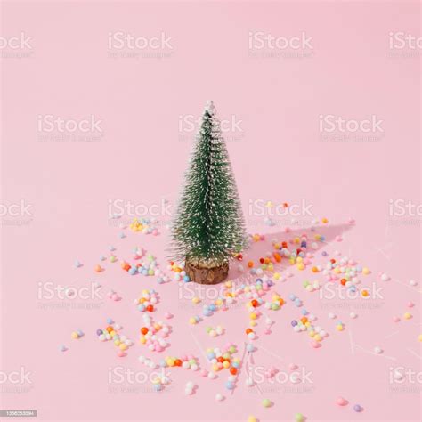 파스텔 핑크 배경에 색종이와 여러 가지 빛깔의 파티 장식 크리스마스 트리 크리스마스와 새해 축하 개념 원근 정사각형 비율을