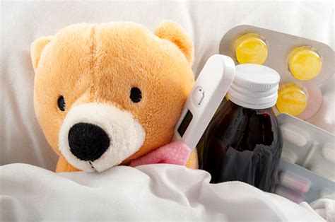 감기와 독감 치료와 소아과 의학 개념 온도계 기침 시럽 목 사탕 알 약 캡슐 및 종이 티슈의 병으로 둘러싸인 흰 담요에 테 디 베어와 함께 0명에 대한 스톡 사진 및 기타