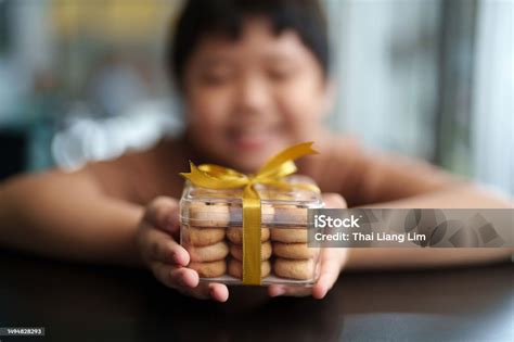 한 소년이 황금 리본이 달린 쿠키 상자를 들고 있다 이미지 선물 상자에 초점을 맞춥니다 선물에 대한 스톡 사진 및 기타 이미지 선물 쿠키 상자 Istock