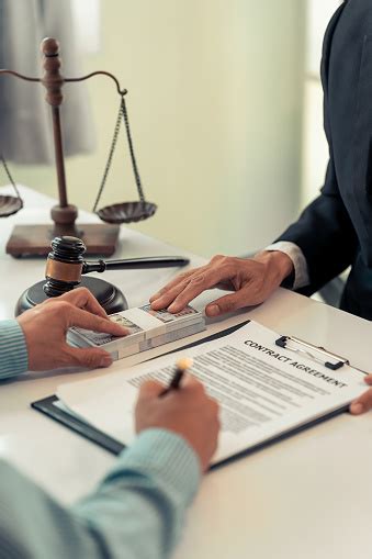 컨설팅과 정의 변호사이자 사업가 일하는 컨설팅 및 협상 의사봉의 클로즈업 남성 변호사 또는 판사가 현대 사무실의 책상 위에서 문서를 읽고 있습니다 2명에 대한 스톡 사진 및