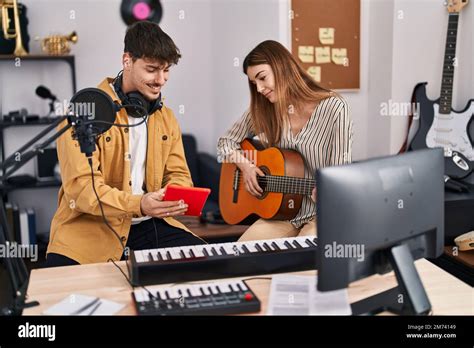 Mand And Woman Musicians Playing Classical Guitar Using Touchpad At