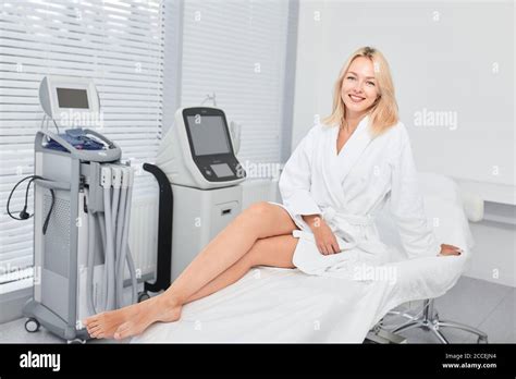 Positive Fair Haired Woman Sitting With Crossed Legs Full Length Photo