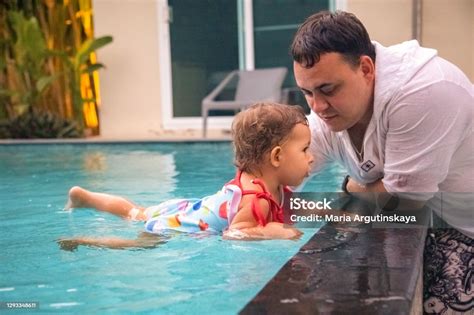 아버지는 수영복을 입은 귀여운 유아 어린 소녀를 가르치고 손을 잡고 수영장에서 수영을합니다 18 23 개월에 대한 스톡 사진 및 기타 이미지 Istock