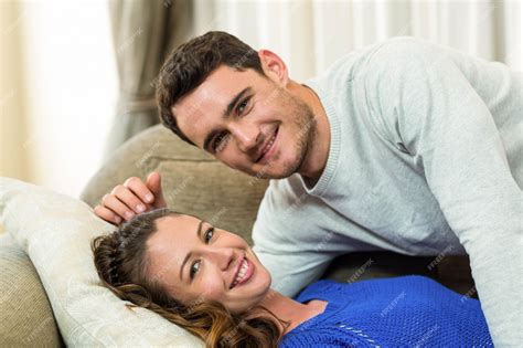 Premium Photo Portrait Of Young Couple Cuddling On Sofa In Living Room