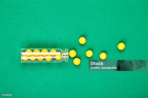 의료 블로그에 대한 미니멀리즘 스타일의 템플릿 작은 유리 병 작은 노란색 알약 녹색 종이 배경 밖으로 유출 제약 개념 약 알 약 플랫 레이 0명에 대한 스톡 사진 및 기타