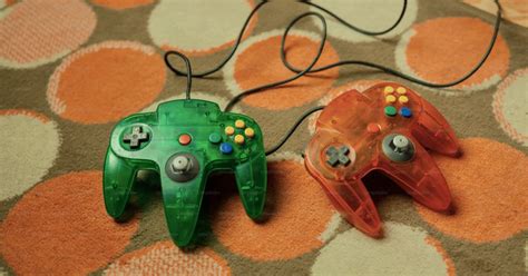 카펫 위에 앉아 있는 두 개의 비디오 게임 컨트롤러 사진 Unsplash의 90년대 이미지