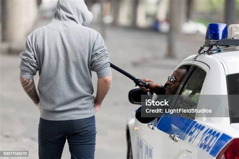 아프리카계 미국인 경찰관 경찰 방망이 들고 두건이 쓴된 남자가 창 밖을 바라보는 동안 중지의 후면 보기 경찰관에 대한 스톡 사진 및 기타 이미지 Istock