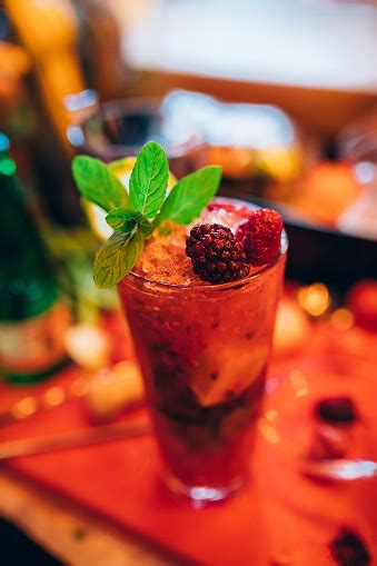 바 데스크에서 라임 민트 딸기 베리를 곁들인 상쾌하고 신선한 컬러풀한 이국적인 알콜 모히토 칵테일 여름 청량 음료 이국적인 다채로운 칵테일입니다 감귤류 과일에 대한 스톡