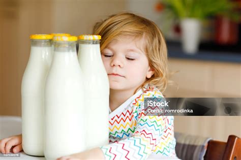 사랑 스러운 유아 여자 아침 식사 암소 우유를 마시는 병이 많은 귀여운 아기 딸 건강 한 아이 칼슘 소스로 우유를가지고 아침에