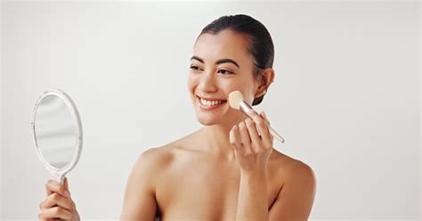 여자 스튜디오 및 흰색 배경에 아름다움 기초 및 응용 프로그램에 대한 메이크업 브러시와 거울에 행복 여성 고립되고 빛나는 변화 및 피부를 위한 모형 공간이 있는 미소 25