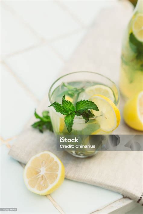 정원의 흰색 테이블에 민트 잎과 얼음 조각 차가운 레모네이드 브라질에서 라임 슬라이스 카이피리냐와 유리 용기에 알코올 모히토 상쾌한 칵테일 복사 공간 레몬 밤에 대한 스톡