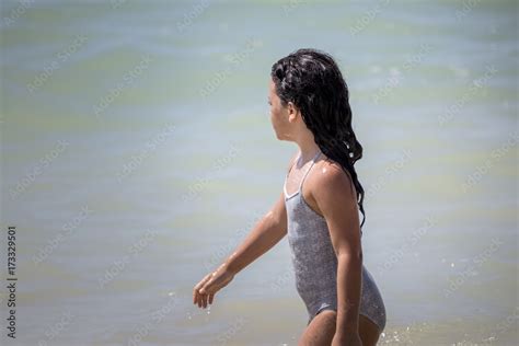 Niña morena bañándose en el mar y jugando con las olas Stock Photo