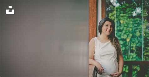 흰색 민소매 드레스를 입고 갈색 나무 난간 동자에 기대어 있는 여자 사진 Unsplash의 무료 여성 이미지