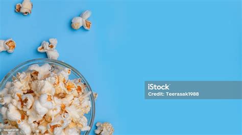 파스텔 블루 배경에 유리 그릇에 맛있는 팝콘 복사 공간이 있는 따뜻한 팝콘의 상위 뷰입니다 영화 스낵 및 엔터테인먼트 개념 0명에 대한 스톡 사진 및 기타 이미지 Istock