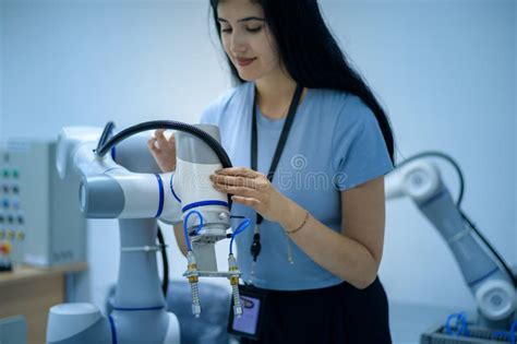 female robotics engineer working with programming and manipulating robot hand industrial
