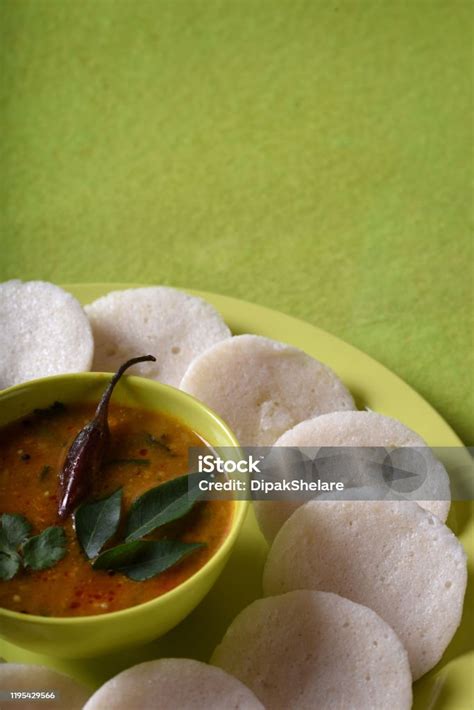 녹색 배경에 그릇에 삼바를 가진 이들리 인도 요리 남부 인도 좋아하는 음식 라바 Idli 또는 세몰리나 또는 라바 삼바와 녹색 코코넛 처트니와 함께 제공됩니다 건강한 생활
