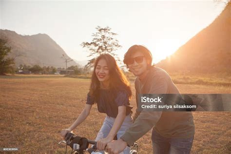 젊은 아시아 남자와 여 자가 연습 감정 편안한 자연 필드에 자전거를 타고의 커플 커플에 대한 스톡 사진 및 기타 이미지 커플