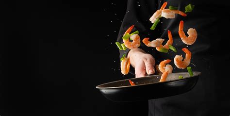 배너 광고 새우를 야채 해산물과 함께 냄비에 요리 검은 배경에 요리사에 의해 전문 요리 유용하고 맛있는 음식 요리 레시피 북 다이어트 및 적절한 영양 굽기에 대한 스톡 사진