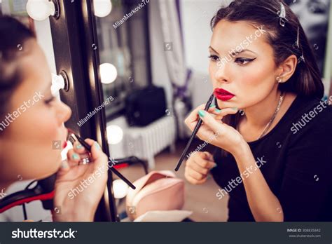 Portrait On Mirror Of A Beautiful Pin Up Girl Applying Red Lipstick To