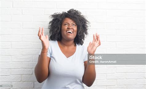 젊은 아프리카계 미국인 플러스 크기 여자 흰 벽돌에 벽 미친 미친 소리 하 고 적극적인 식와 팔 발생 함 좌절 개념입니다 감정에