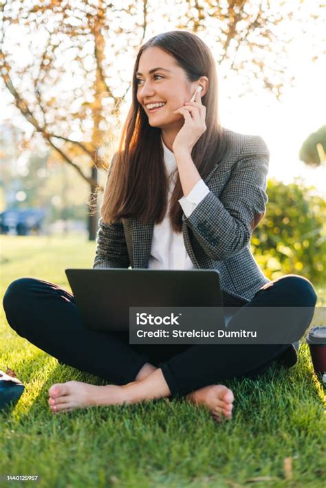 여름날 다리를 꼬고 공원의 푸른 잔디에 앉아 노트북으로 작업하는 아름다운 웃는 여자의 초상화 교육 인터넷 기술 인터넷 통신 25 29세에 대한 스톡 사진 및 기타 이미지