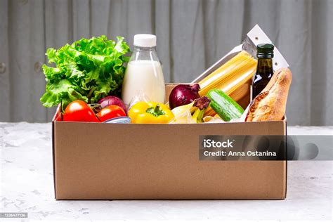 다양한 음식과 기부 상자 기름 야채 우유 통조림 식품 시리얼 및 파스타와 오픈 골판지 상자 텍스트 공간이 있는 음식 배달 개념