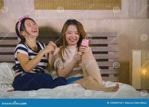 Young Happy And Pretty Asian Korean Girlfriends Sitting At Home Bedroom