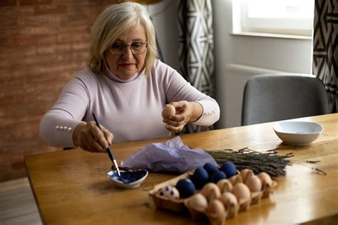 여자는 조심스럽게 전통적인 부활절에 대한 계란에 디자인을 페인트 4월에 대한 스톡 사진 및 기타 이미지 4월 60 64세 가정 생활 Istock