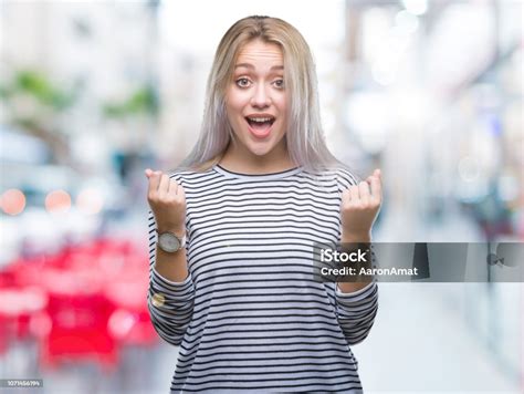 격리 된 배경 축 하에 젊은 금발의 여 자가 놀란 고 팔 제기 성공을 위한 놀라게 했 고 눈 우승자 개념입니다 금발 머리에 대한 스톡 사진 및 기타 이미지 Istock