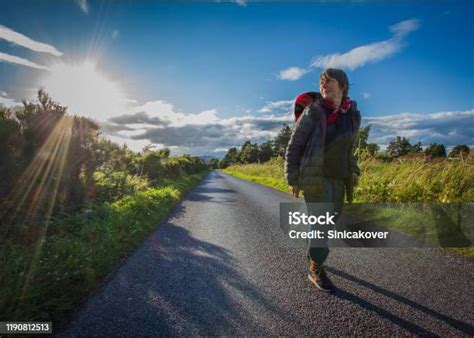 활동적인 라이프스타일 사람들 60 세 이상 한 여자가 일몰에 태양 아래에서 길을 따라 걷습니다 거리에 대한 스톡 사진 및 기타