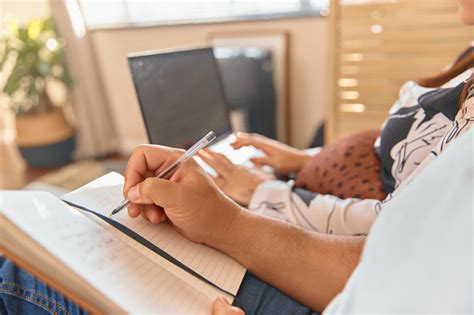 집에서 손 책 부부 글쓰기 집에서 연구 또는 정보 노트북 일기장 남자는 메모를 쓰고 일정을 계획하고 임산부와 함께 노트북에 온라인으로 타이핑하는 작가를 쓴다 인사장에 대한