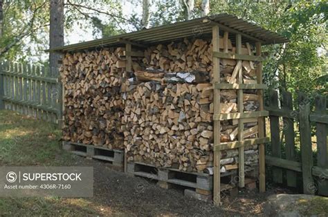 Stack Of Logs In Wooden Shed Superstock