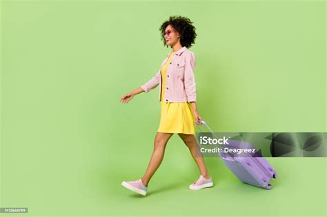 예쁜 밀레니엄 세대 소녀의 전체 길이 프로필 초상화는 녹색 배경에 고립 된 가방 산책 등록을 보류합니다 걷기에 대한 스톡 사진