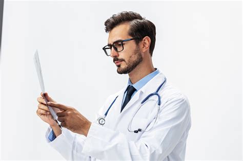 흰 가운과 안경 청진기를 착용한 남성 의사는 흰색 고립된 배경 복사 공간 텍스트를 위한 공간 건강 상태에서 진단을 위한 엑스레이 환자의 사진을 주의 깊게 바라봅니다 25