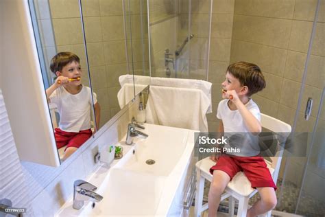 귀여운 어린 소년이 칫솔로 이빨을 닦고 있습니다 그가 옷을 입고있는 순수한 흰색 티셔츠에 당신은 광고 비문을 만들 수 있습니다 어린이 건강 의학의 개념 6 7 살에 대한