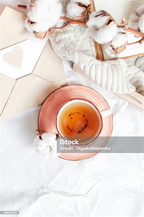 면 나무 트레이 니트 격자 무늬 스웨터 오픈 노트북 러브 레터의 뜨거운 차 가지 컵 침대에 집에서 아늑한 아침 식사 라이프스타일 부드러운 배경 복사 공간 가을 겨울 컨셉 0