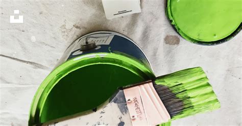 초록색 페인트 캔과 브러시가 박스형 물 상자 옆에 놓여 있습니다 사진 Unsplash의 무료 박스형 물 이미지