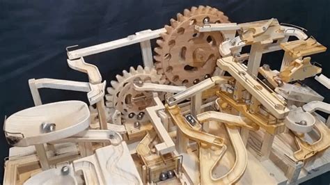 A Wooden Marble Machine That Uses Gears And Lifts To Endlessly Push