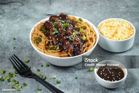 파 양파 매운 소스 양배추 샐러드 포크를 곁들인 데리야끼 그릴 치킨 누들이 회색 배경에 고립된 그릇에 담겨 일본 음식의 측면 모습 0명에 대한 스톡 사진 및 기타 이미지