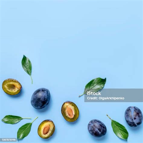 푸른 배경 플랫 평지 상단 뷰 복사 공간에 신선한 잘 익은 매실과 녹색 잎 매화 전체와 반쪽 매화 추상적 인 배경 과일 열대 패턴 음식 건강한 유기농 식사 수확 개념 건강한