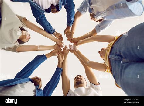 Happy Team Of Young People Raise Their Hands And Join Them Together Showing Unity And Solidarity